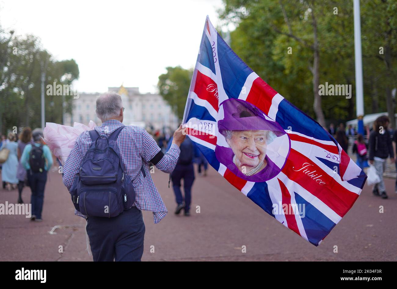 © Jeff Moore A man holds a Union Jack flag as he heads down the Mall to ...