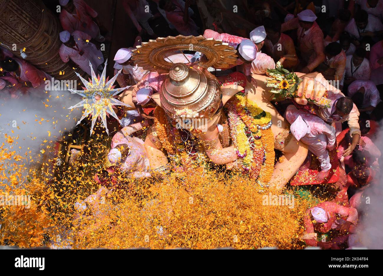 Devotees shower flower petals on the idol of elephant-headed Hindu god ...