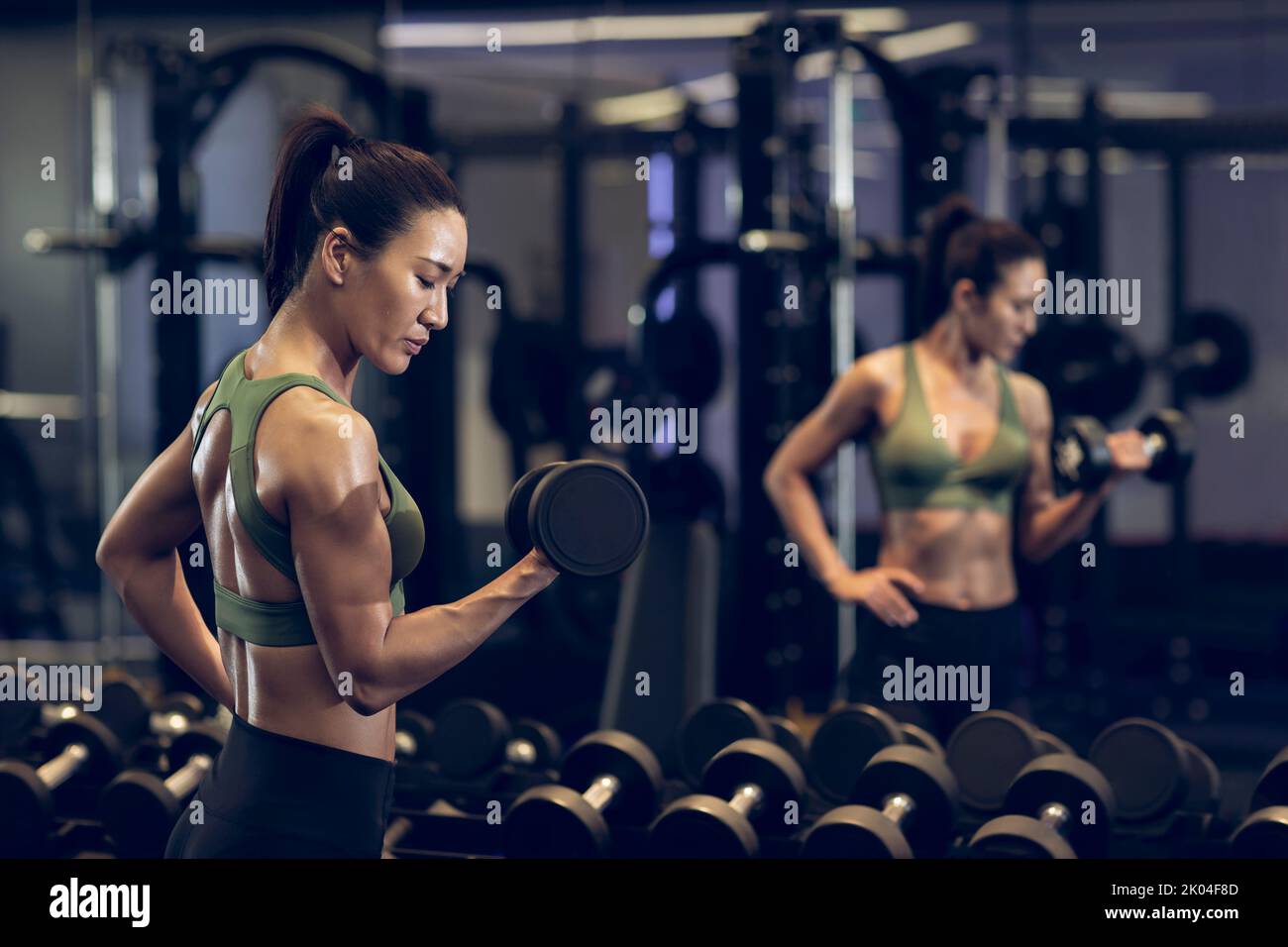 Young Chinese woman working out with dumbbell at gym Stock Photo - Alamy