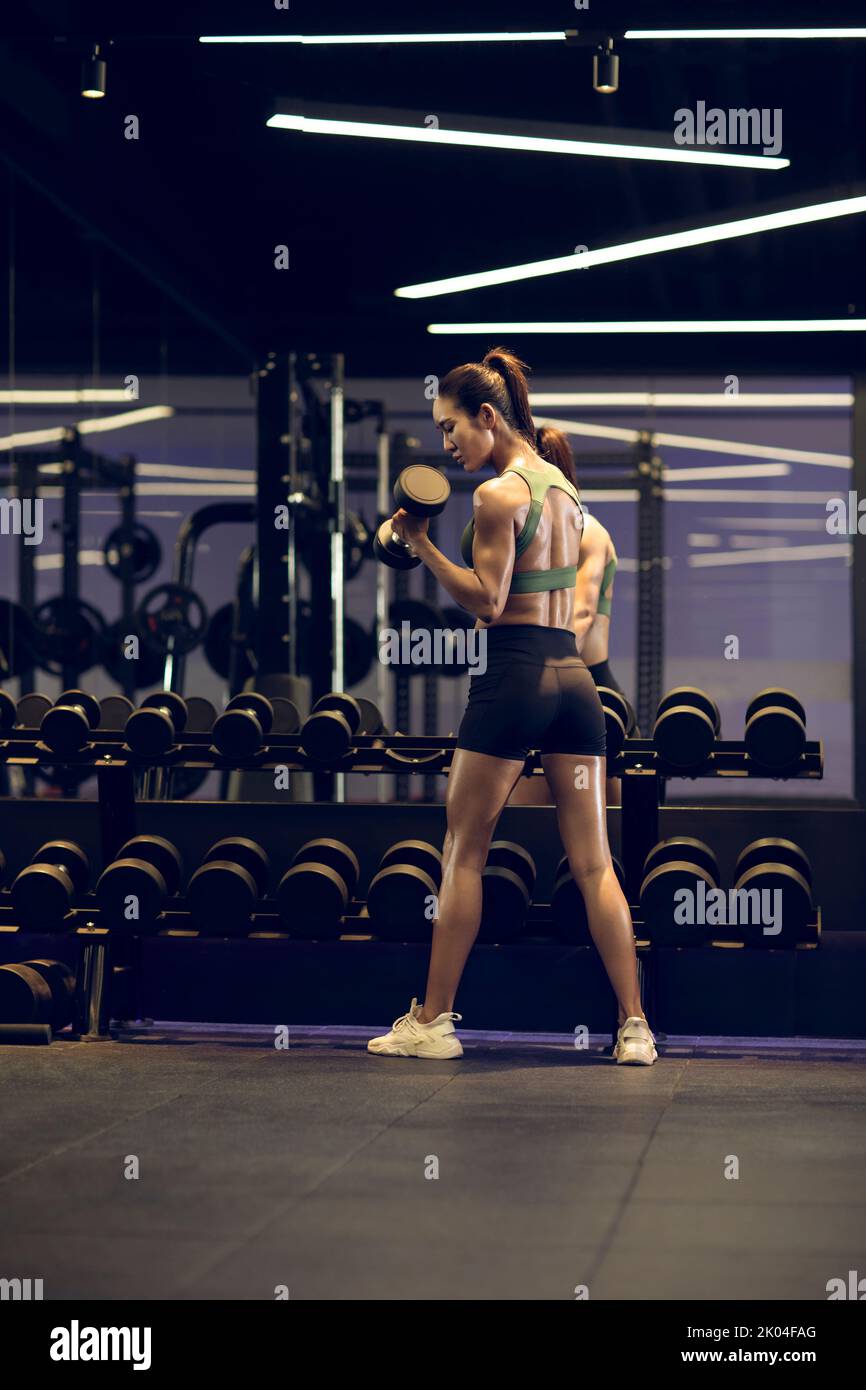 Young Chinese woman working out with dumbbell at gym Stock Photo - Alamy