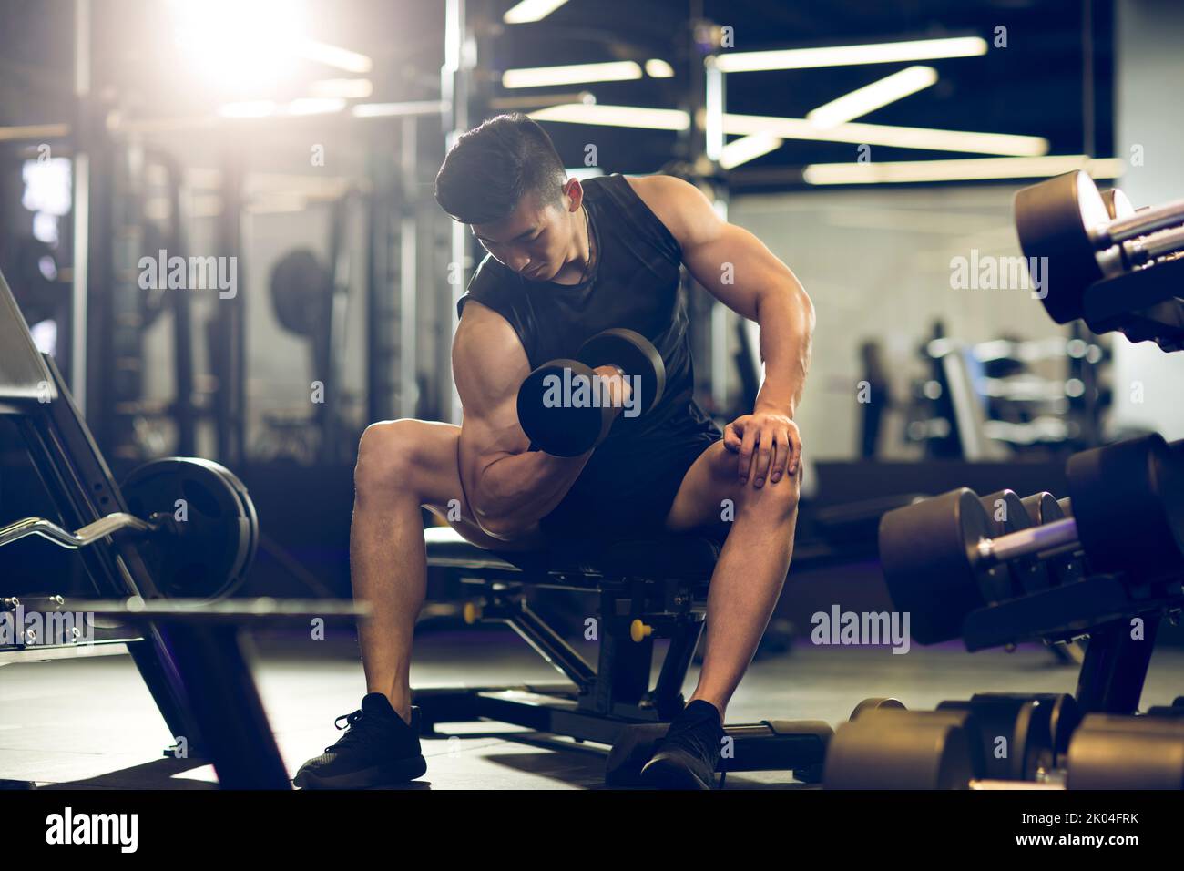 Young Chinese man working out with dumbbell at gym Stock Photo - Alamy