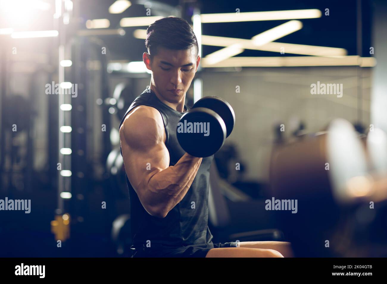 Young Chinese man working out with dumbbell at gym Stock Photo - Alamy
