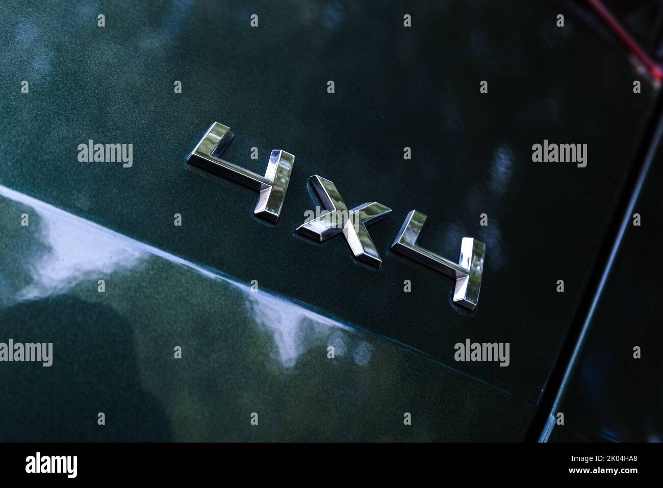 All wheel drive sign, shiny metallic text 4x4 on a modern SUV car back ...