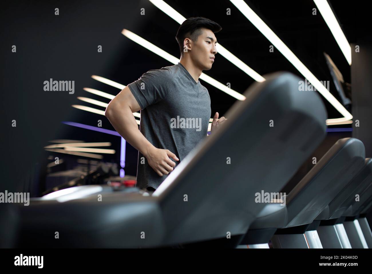 Young Chinese man running on treadmill at gym Stock Photo - Alamy