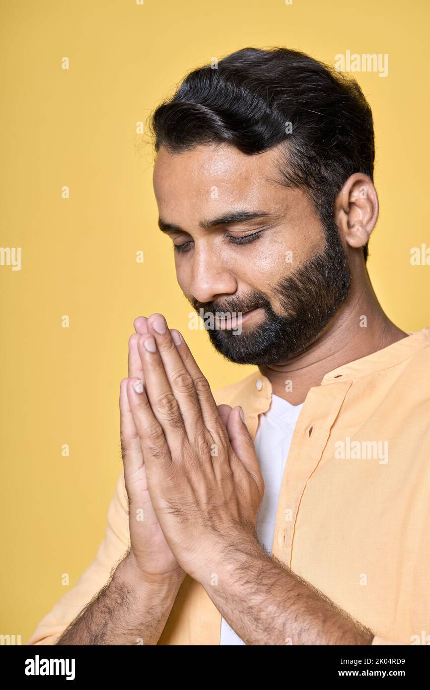 Mindful indian man meditating holding hands in namaste isolated on yellow Stock Photo - Alamy