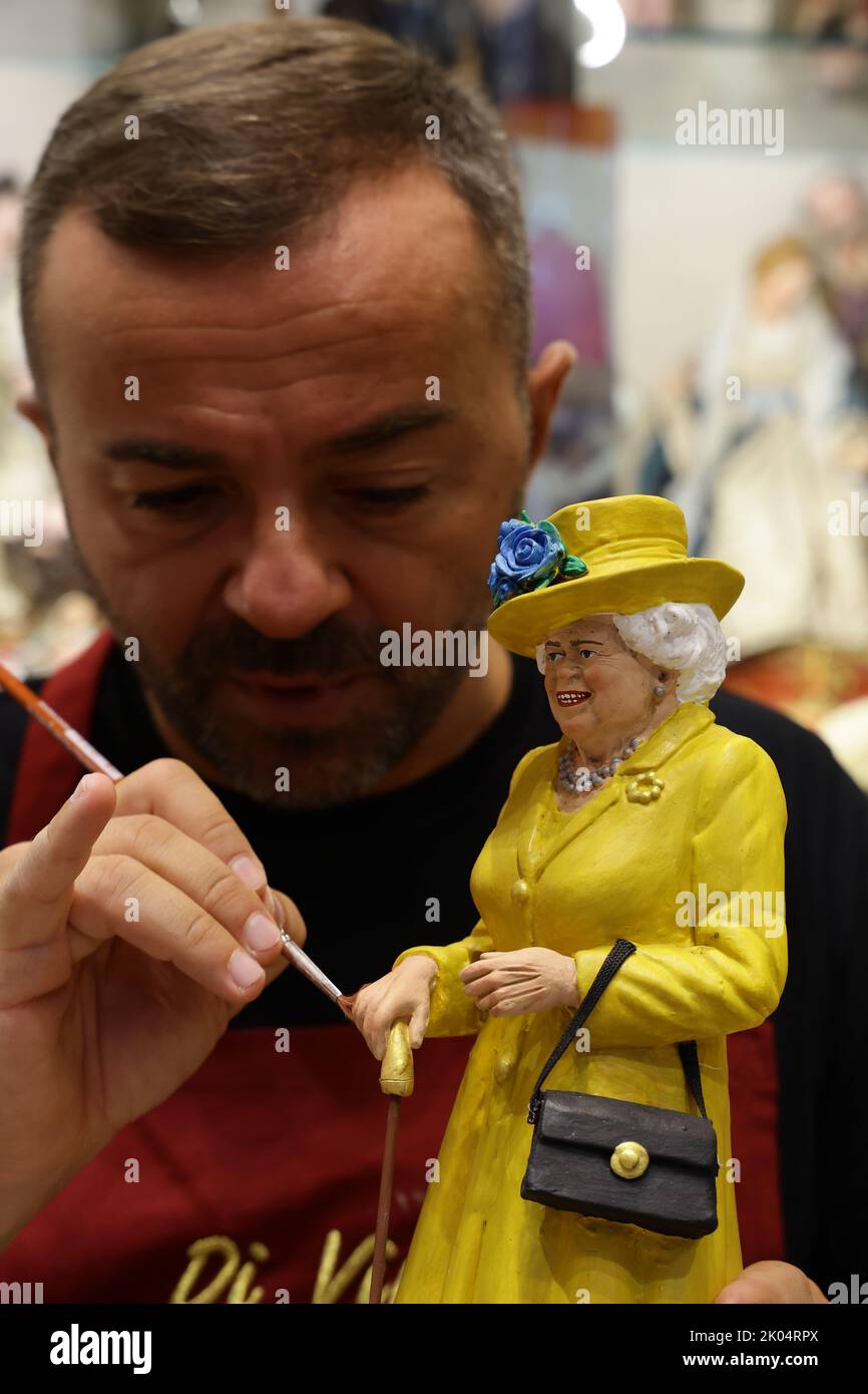 Craftsman Gennaro Di Virgilio works on a figurine depicting Queen ...