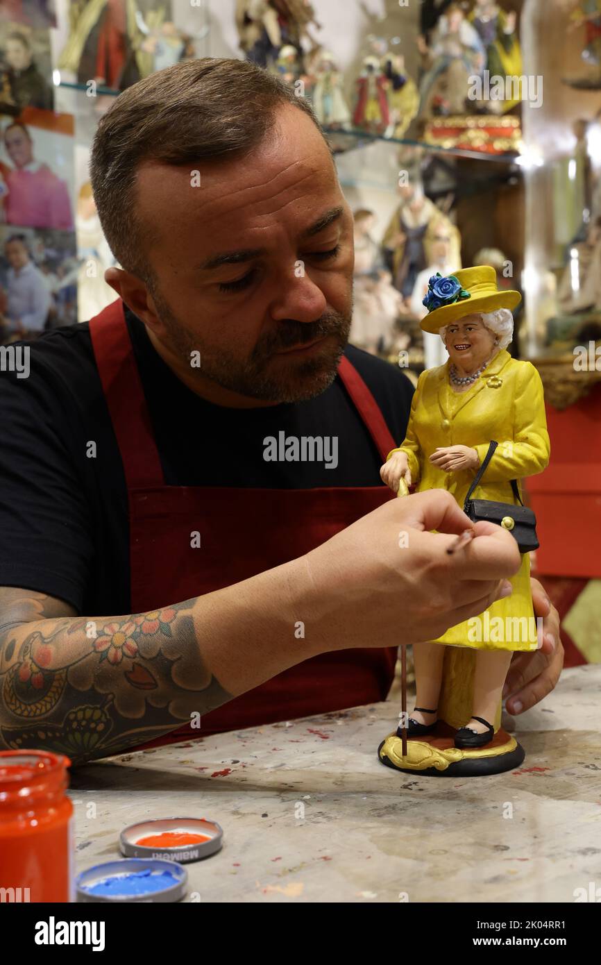 Craftsman Gennaro Di Virgilio works on a figurine depicting Queen ...
