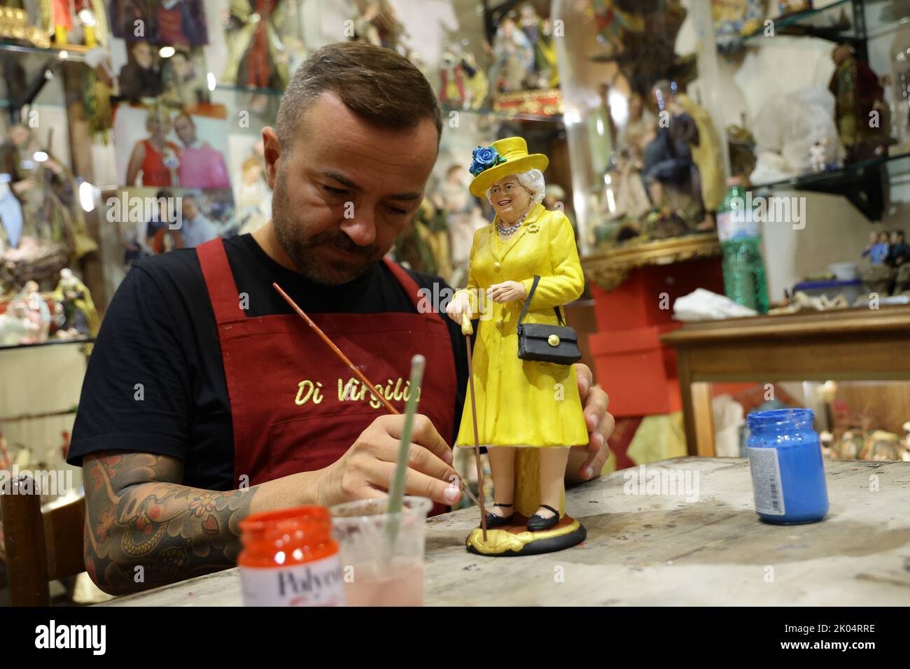 Craftsman Gennaro Di Virgilio works on a figurine depicting Queen ...