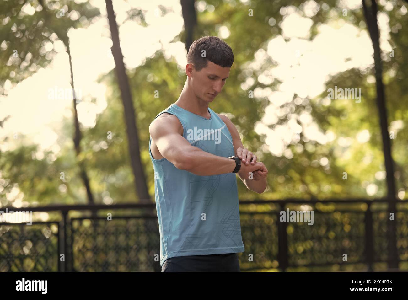 man runner in activewear checking time on smartwatch Stock Photo - Alamy