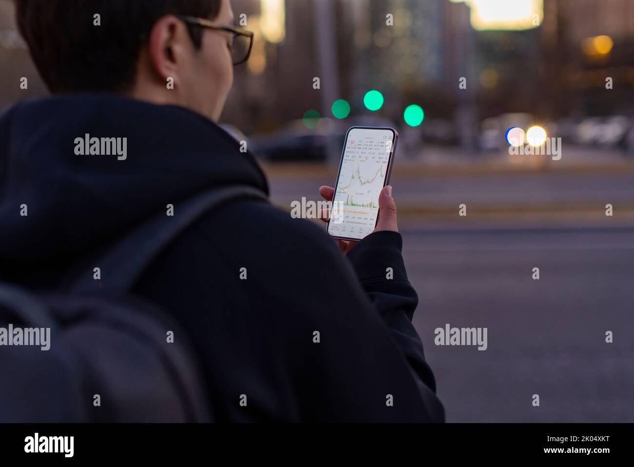 A man checking stock market data on smartphone Stock Photo - Alamy