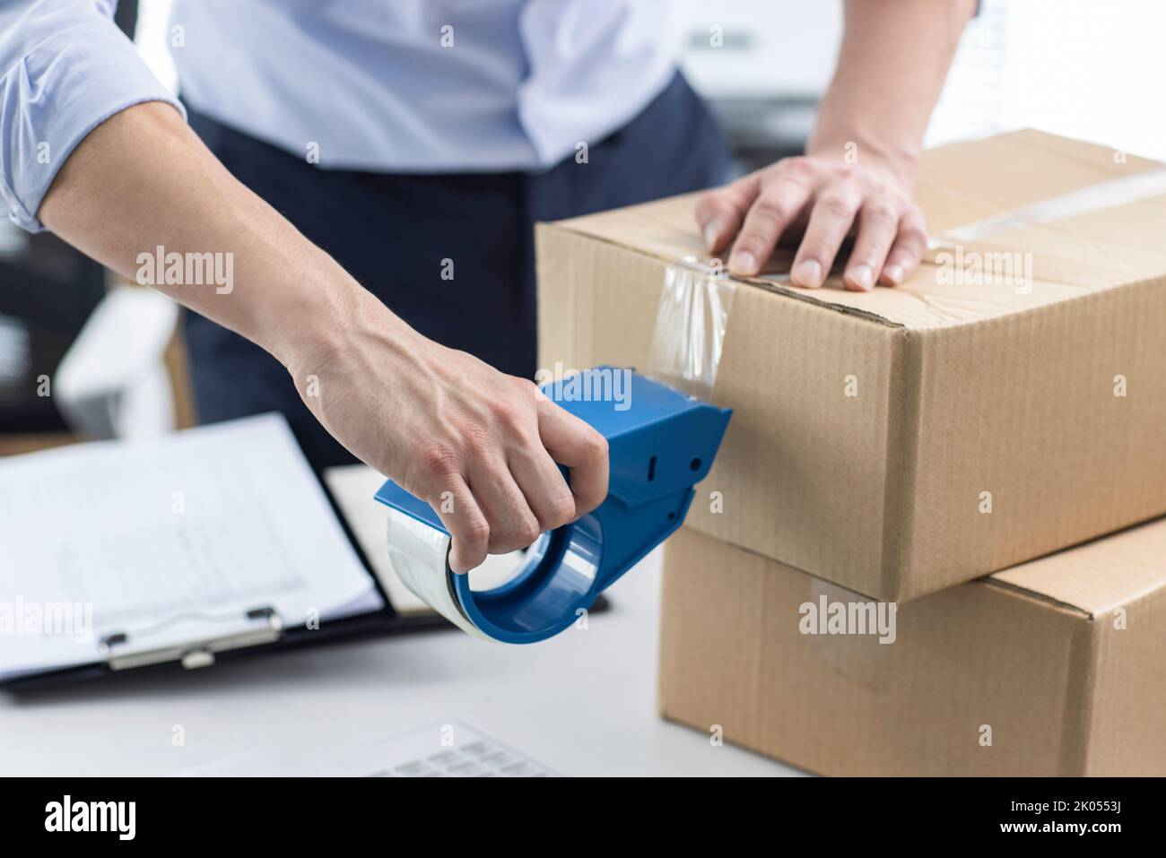 Chinese small business owner packing boxes in office Stock Photo - Alamy
