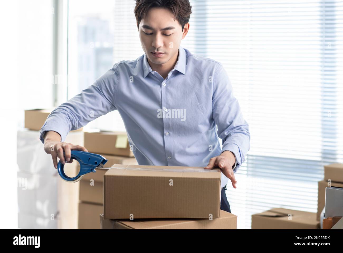 Chinese small business owner packing boxes in office Stock Photo - Alamy