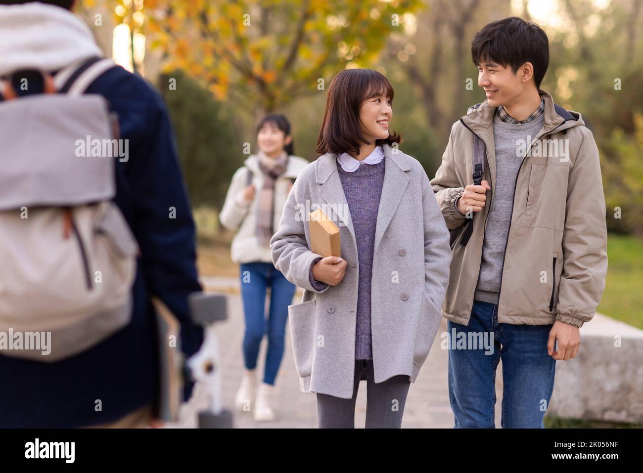 Happy Chinese college students walking on campus Stock Photo - Alamy