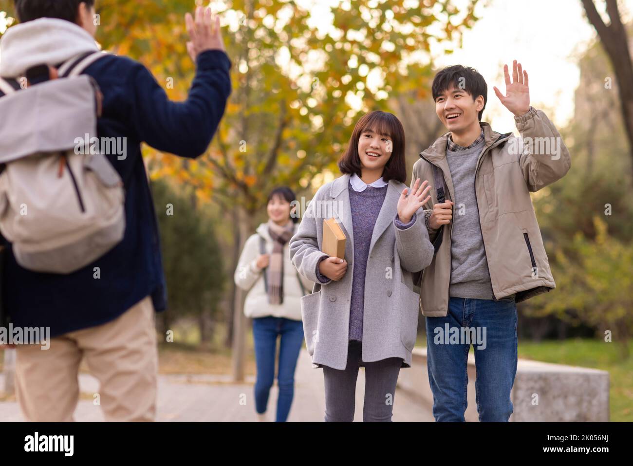 Happy Chinese college students greeting on campus Stock Photo - Alamy