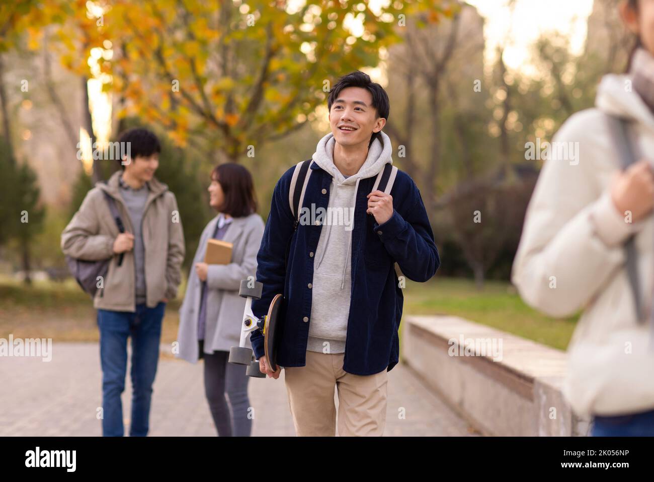 Happy Chinese college students walking on campus Stock Photo - Alamy