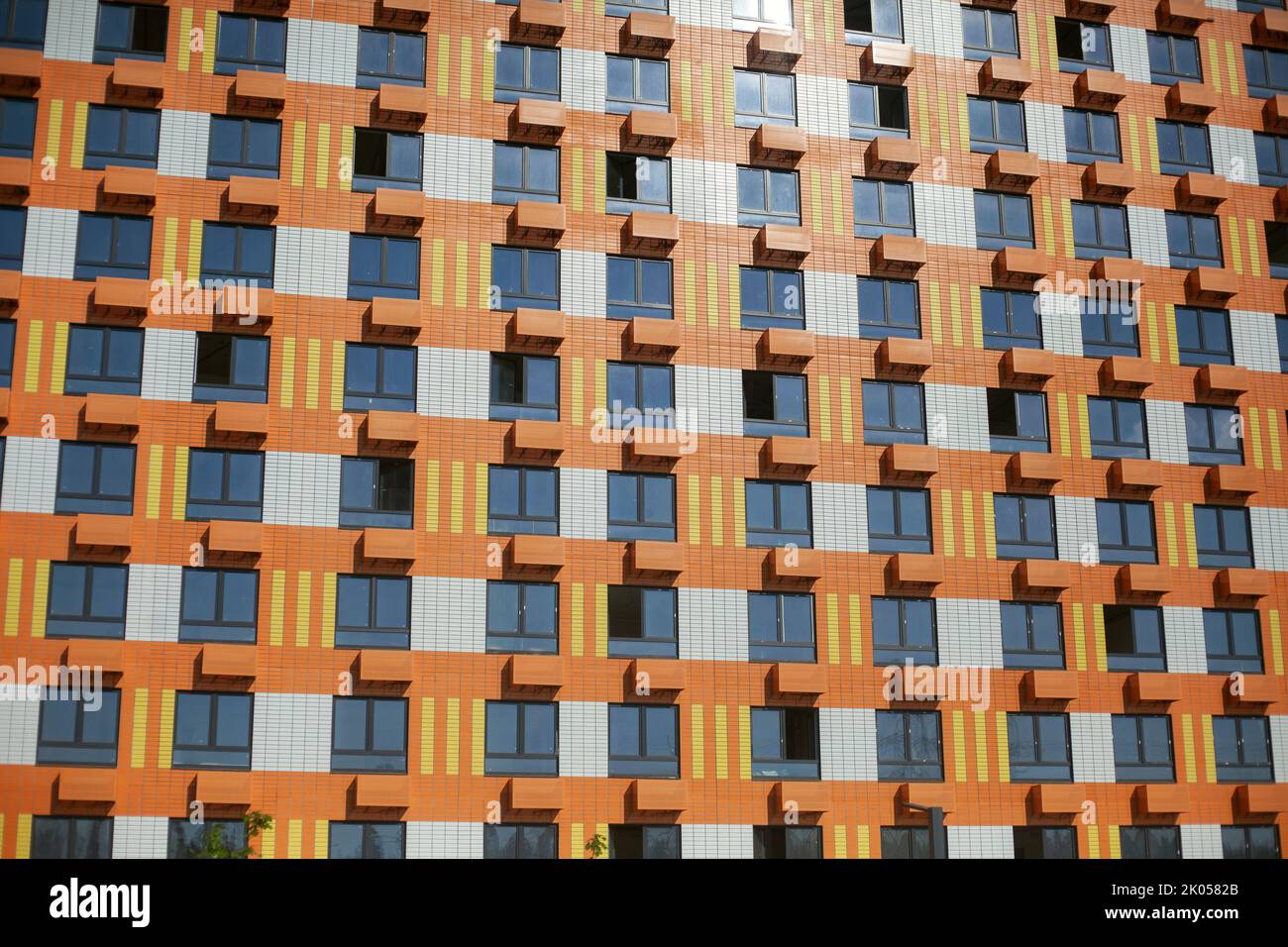 Orange building in modern style. House with identical windows. Lot of ...