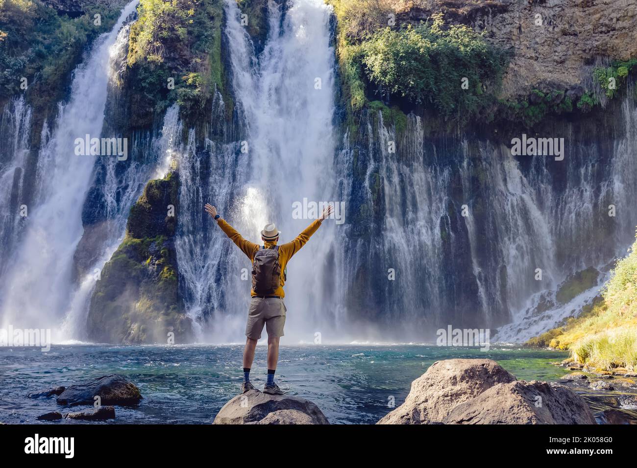 Man traveler standing with his hands raised with a view on the ...