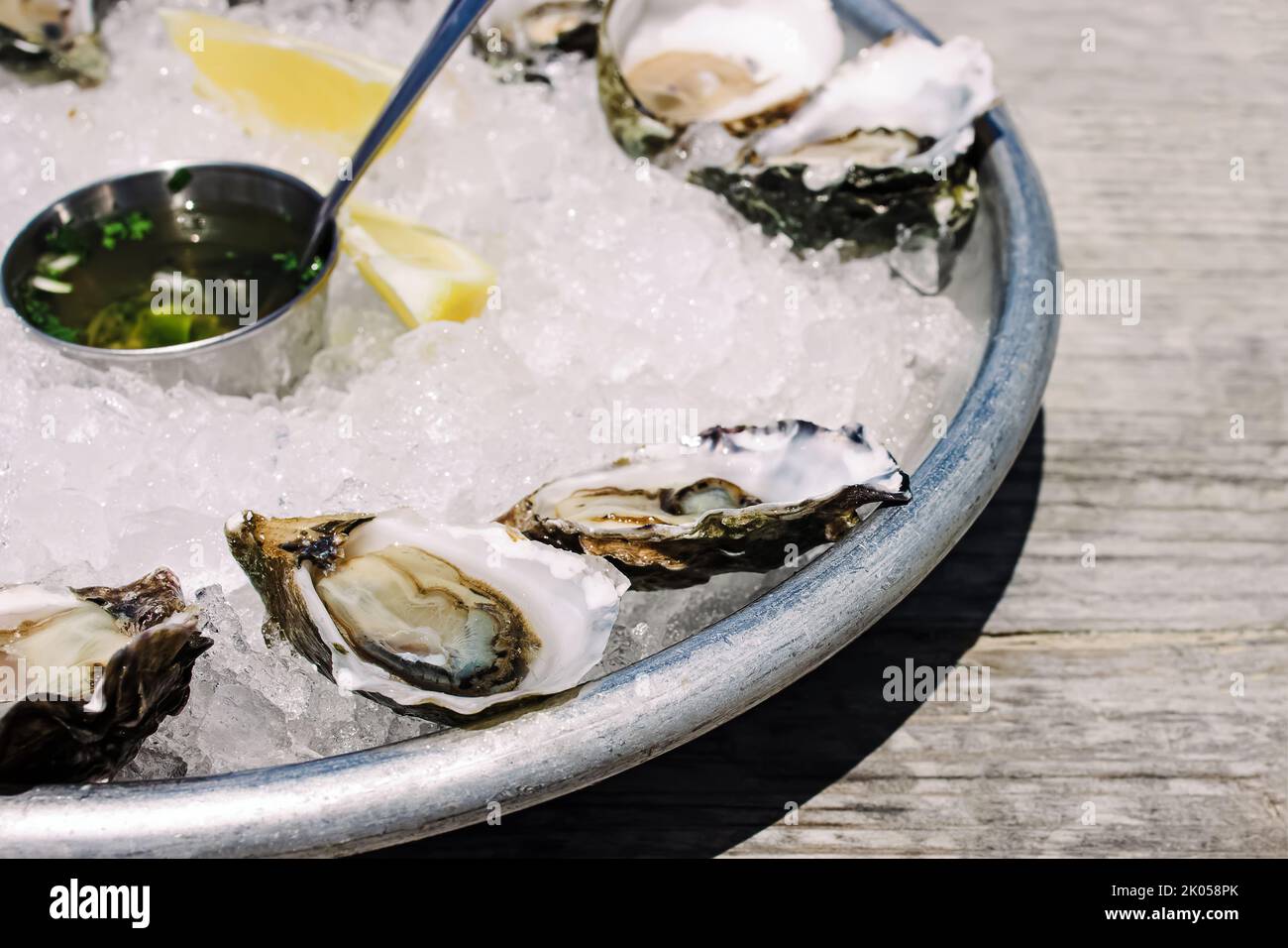 Fresh oyster on the ice in outdoor cafe in natural sunlight , close-up ...