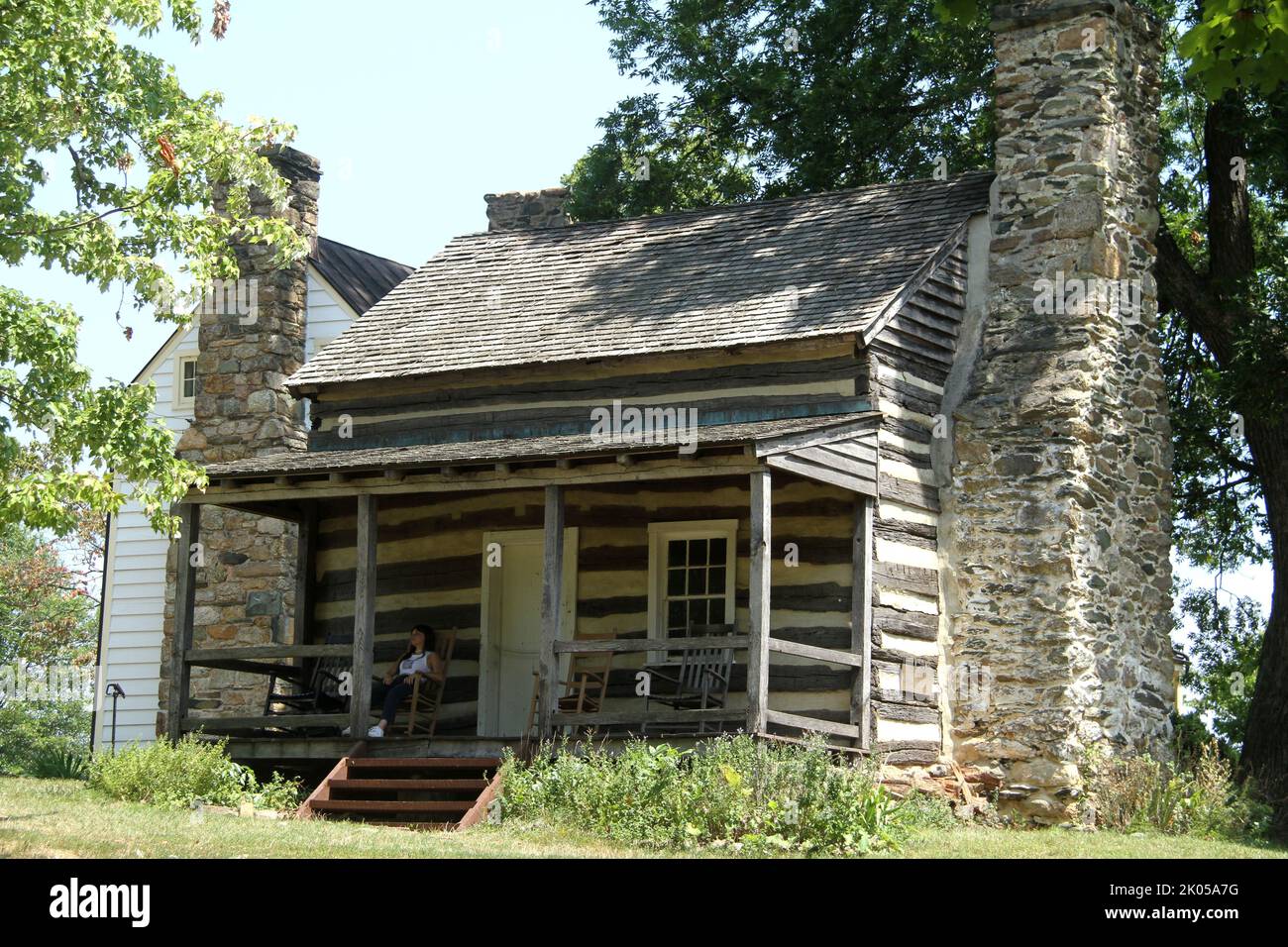 Historical log cabin with a porch and a stone chimney at Sky Meadows ...