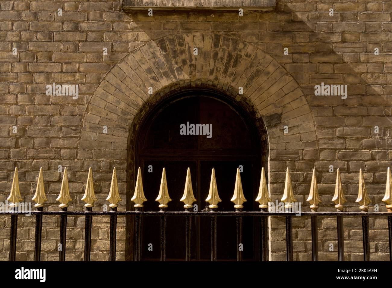 Close-up of massive steel fence with vertical lances with gilded tops ...