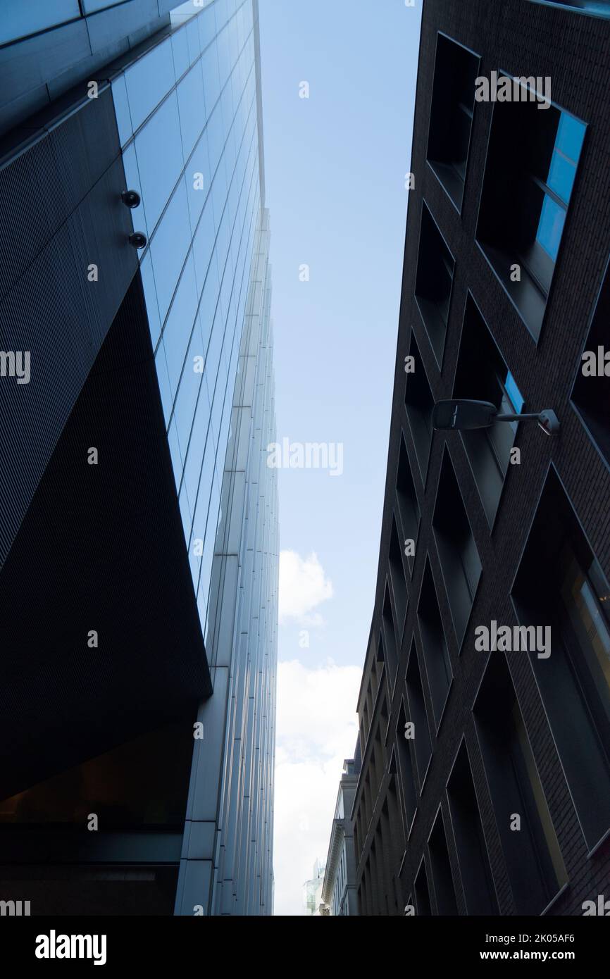 View up between a skyscraper and a commercial building seen from below ...