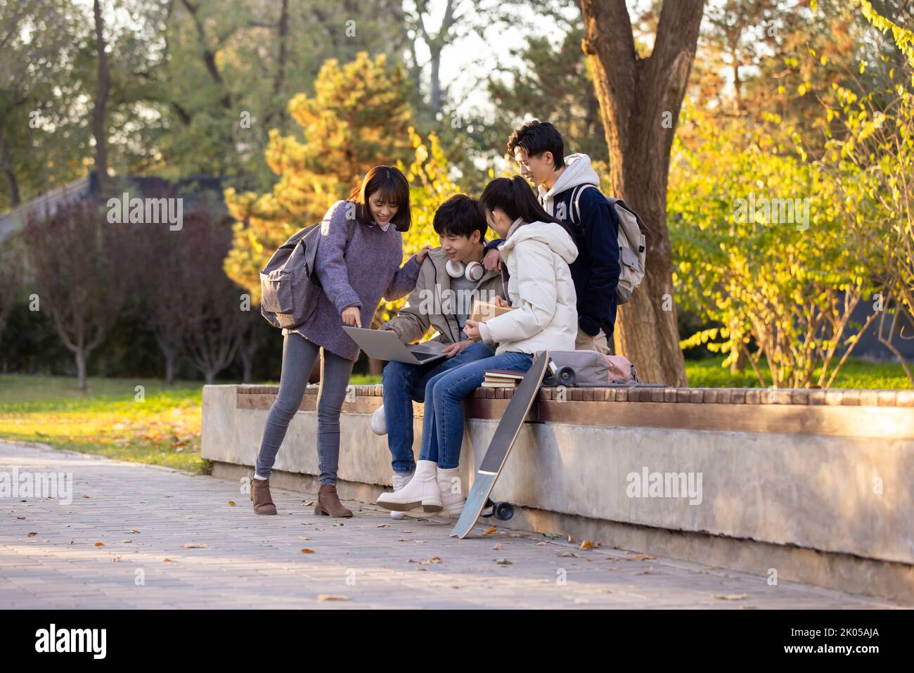 Happy Chinese college students using laptop on campus Stock Photo - Alamy