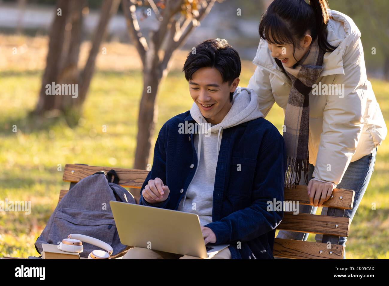 Happy Chinese college students using laptop on campus Stock Photo - Alamy
