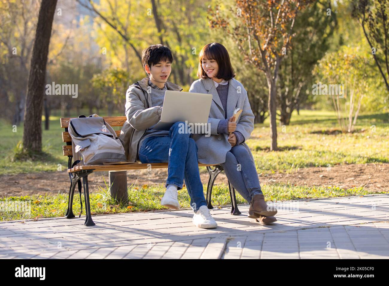 Happy Chinese college students using laptop on campus Stock Photo - Alamy