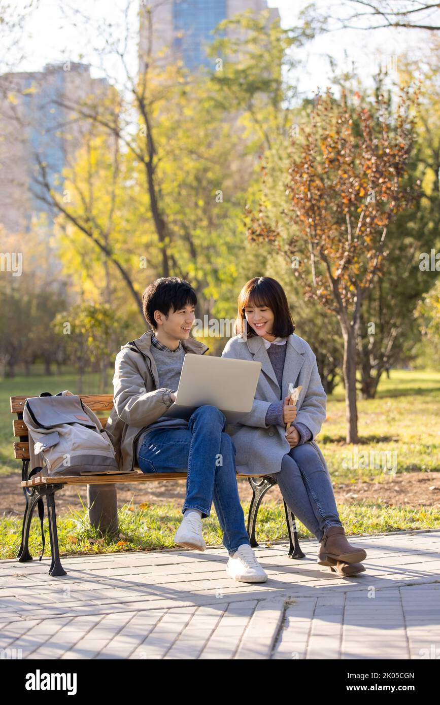 Happy Chinese college students using laptop on campus Stock Photo - Alamy