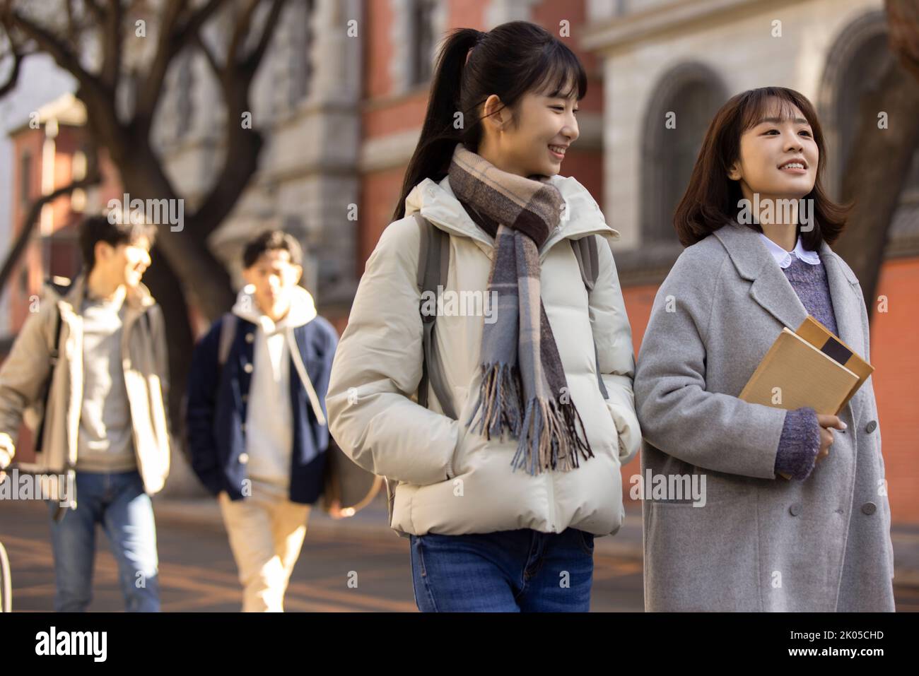 Happy Chinese college students walking on campus Stock Photo - Alamy