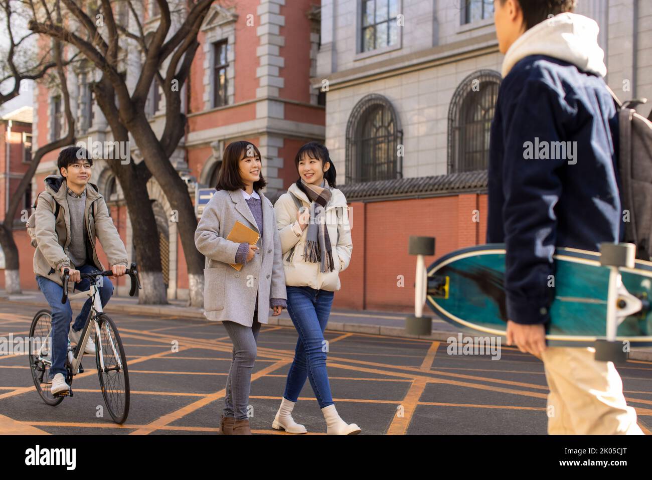 Happy Chinese college students walking on campus Stock Photo - Alamy