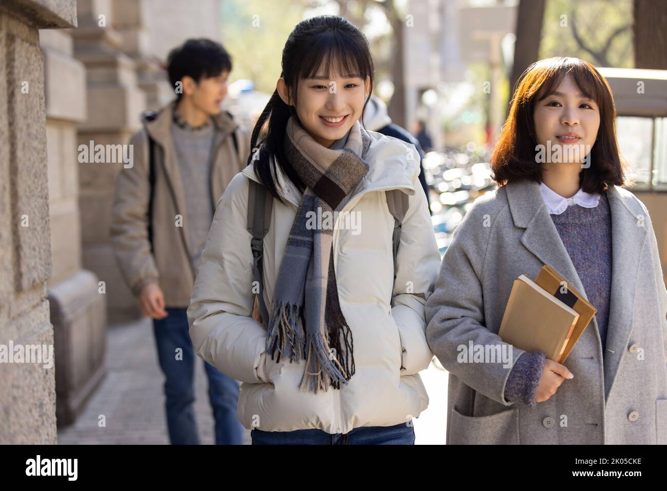 Happy Chinese college students walking on campus Stock Photo - Alamy