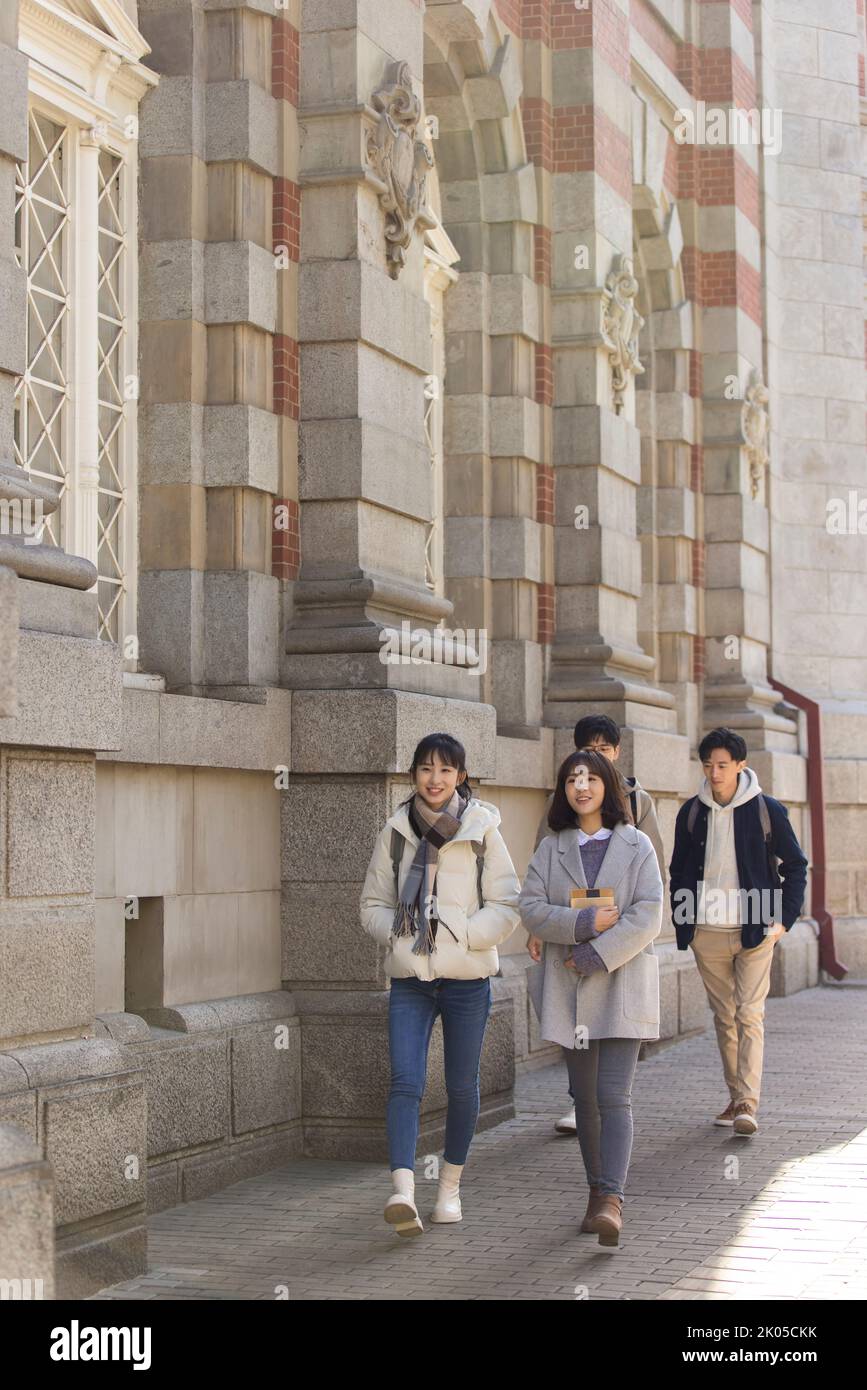 Happy Chinese college students walking on campus Stock Photo - Alamy