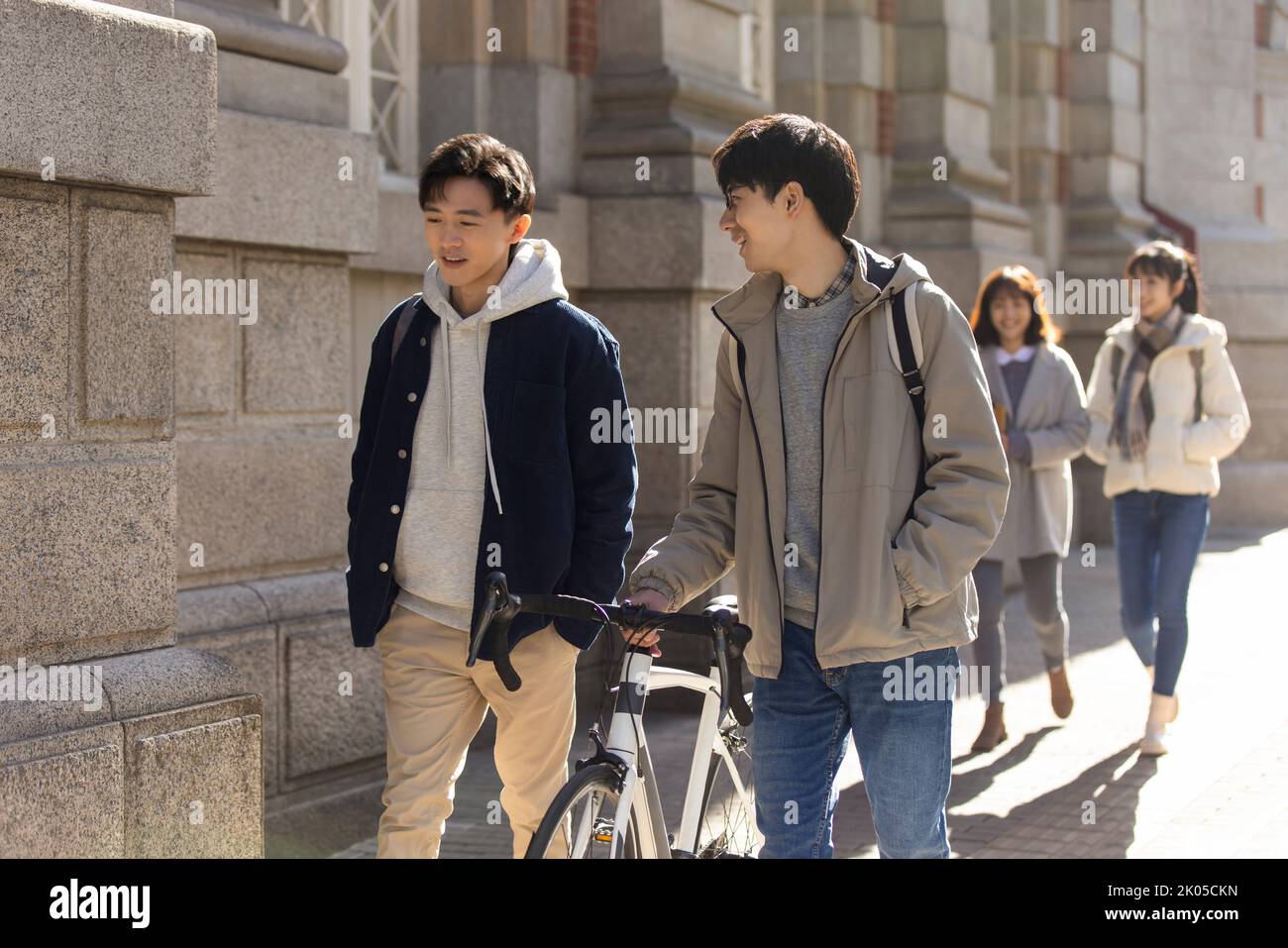 Happy Chinese college students walking on campus Stock Photo - Alamy