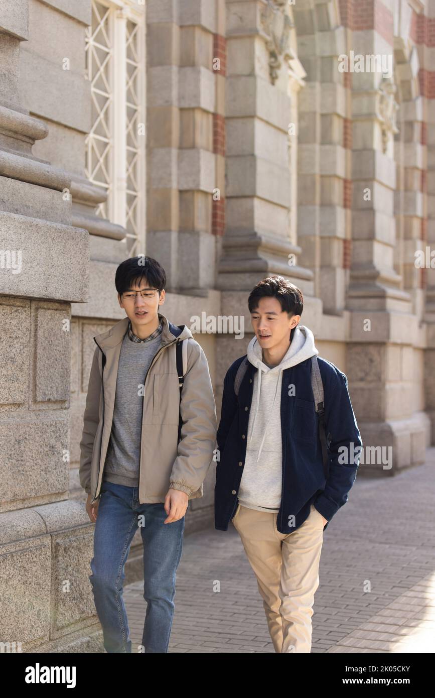 Happy Chinese college students walking on campus Stock Photo - Alamy