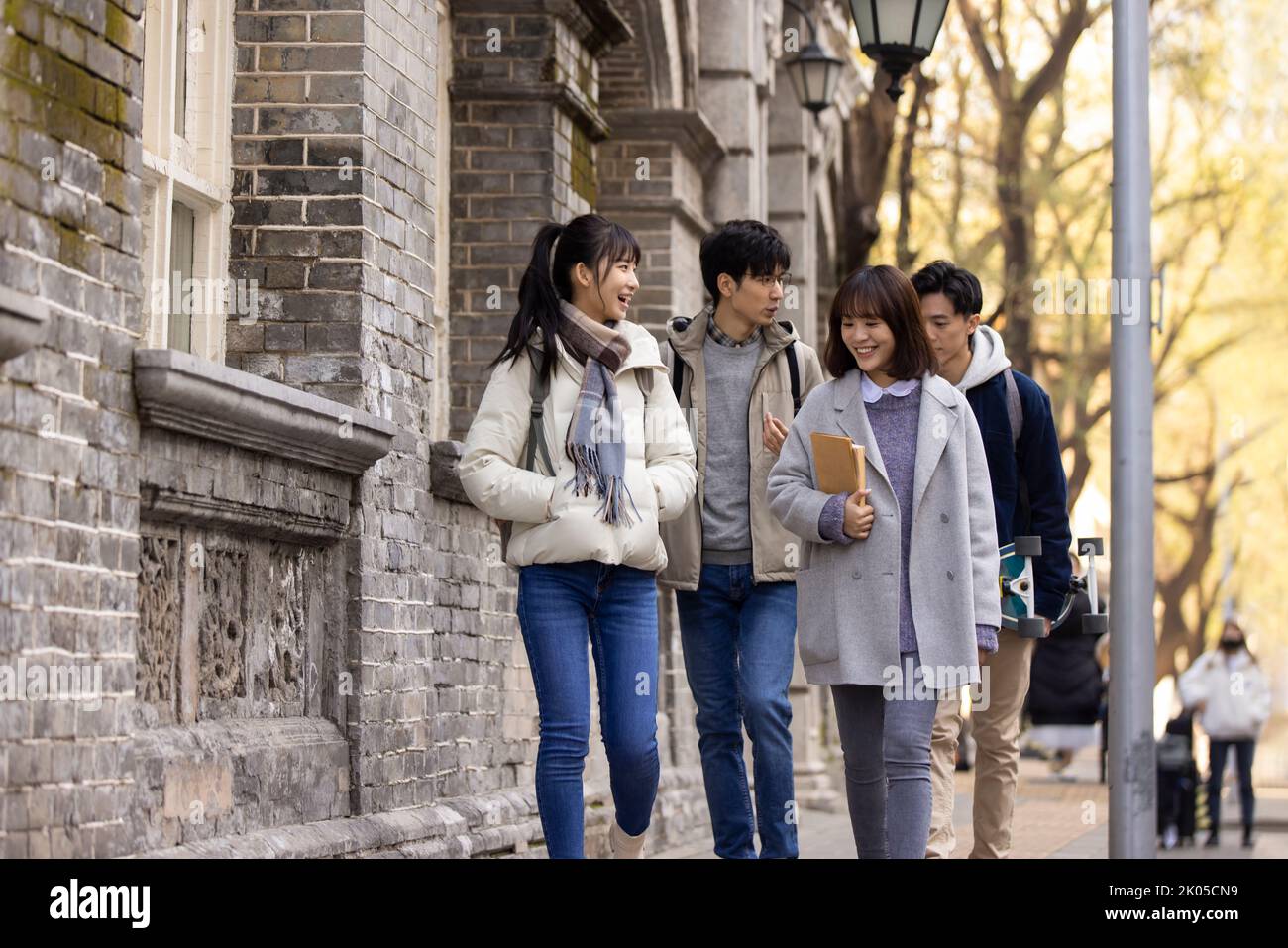 Happy Chinese college students walking on campus Stock Photo - Alamy