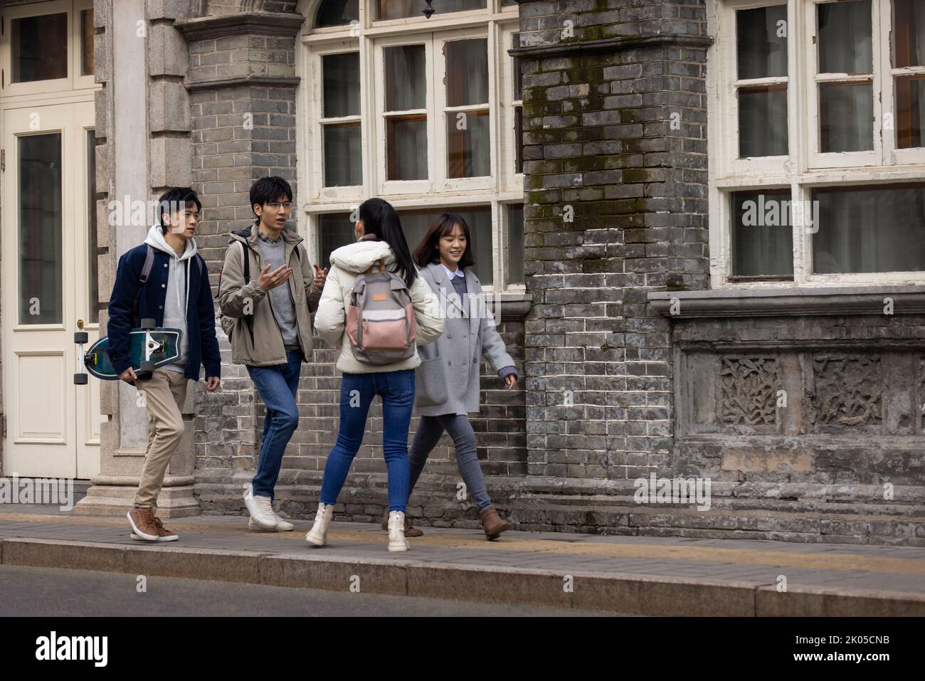 Happy Chinese college students walking on campus Stock Photo - Alamy