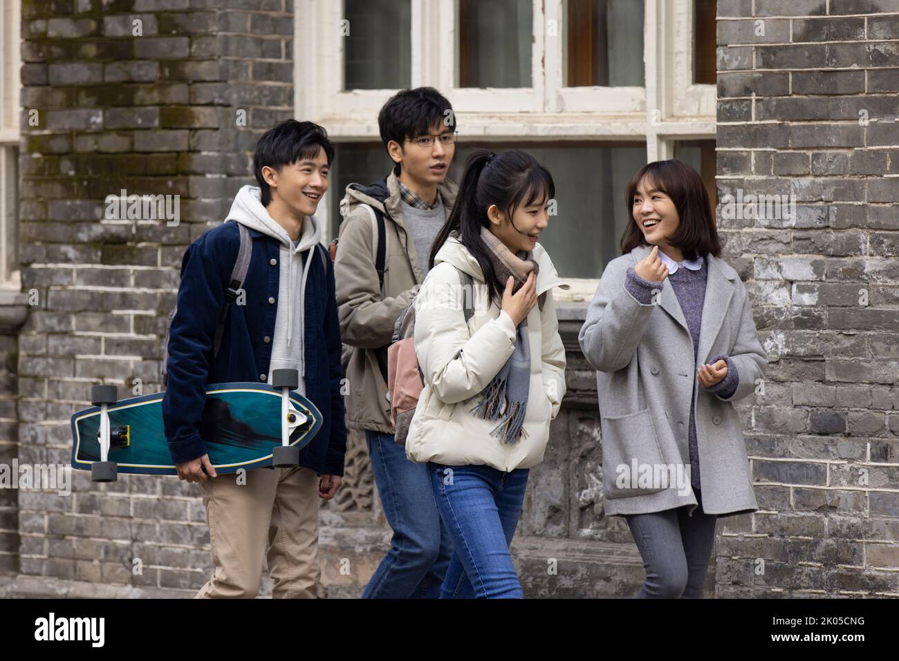 Happy Chinese college students walking on campus Stock Photo - Alamy