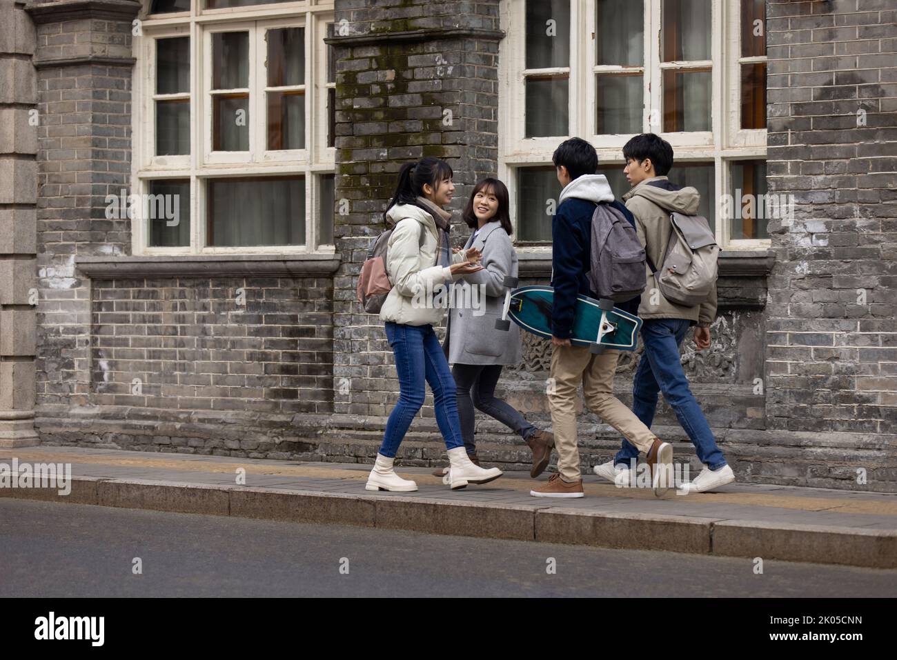 Happy Chinese college students walking on campus Stock Photo - Alamy