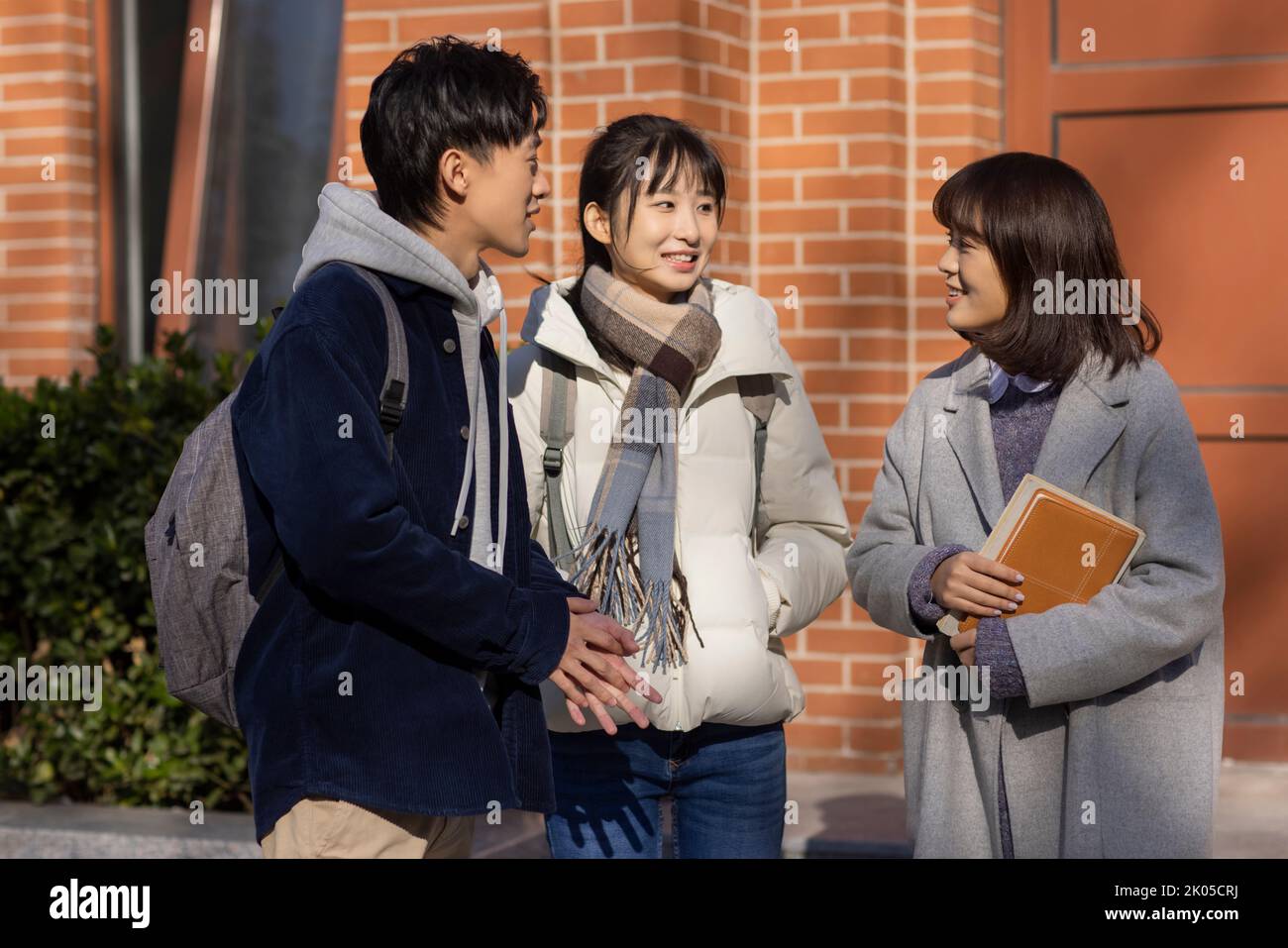 Three college students standing talking hi-res stock photography and ...