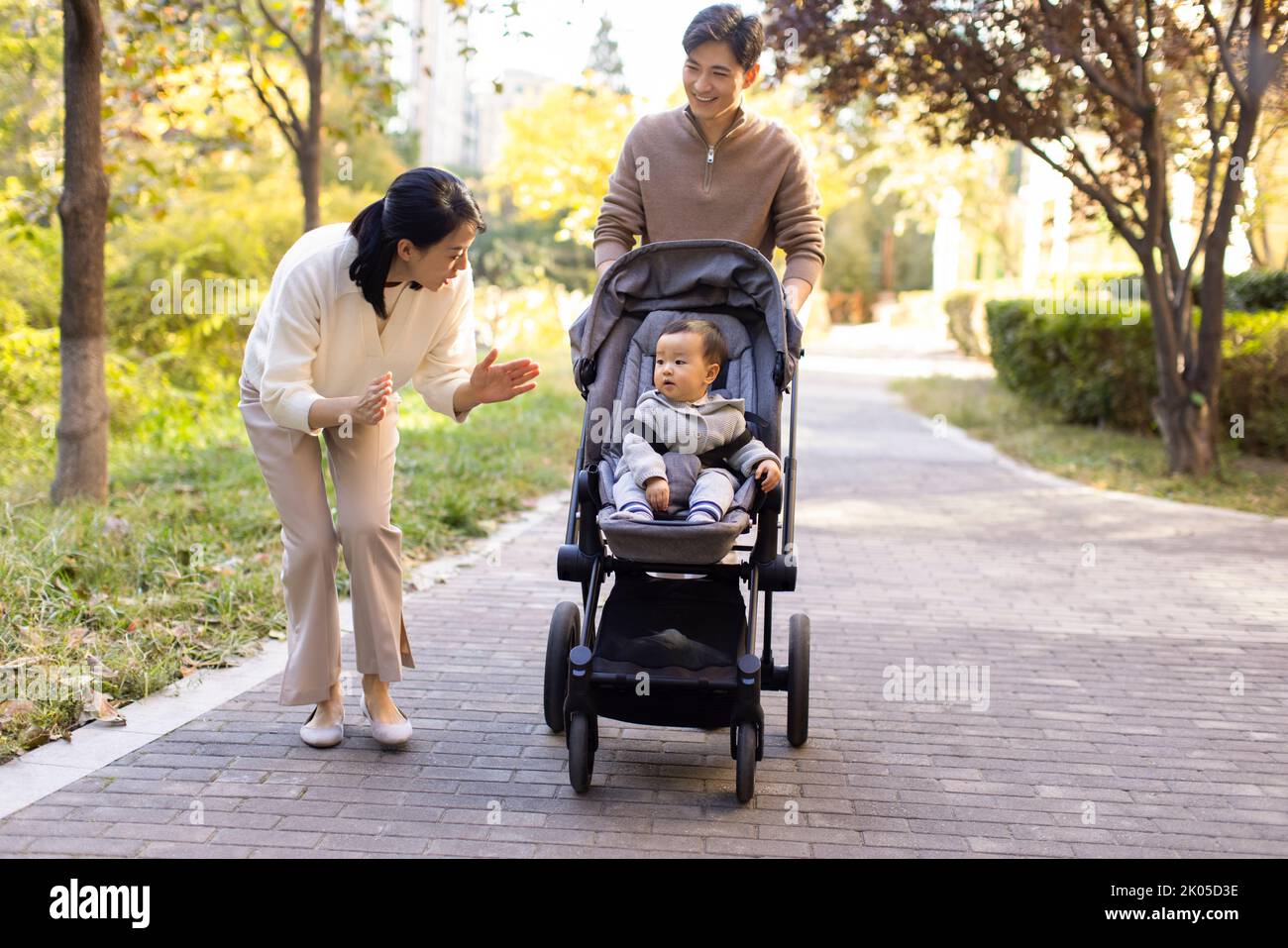 Young Chinese parents with baby in stroller Stock Photo - Alamy