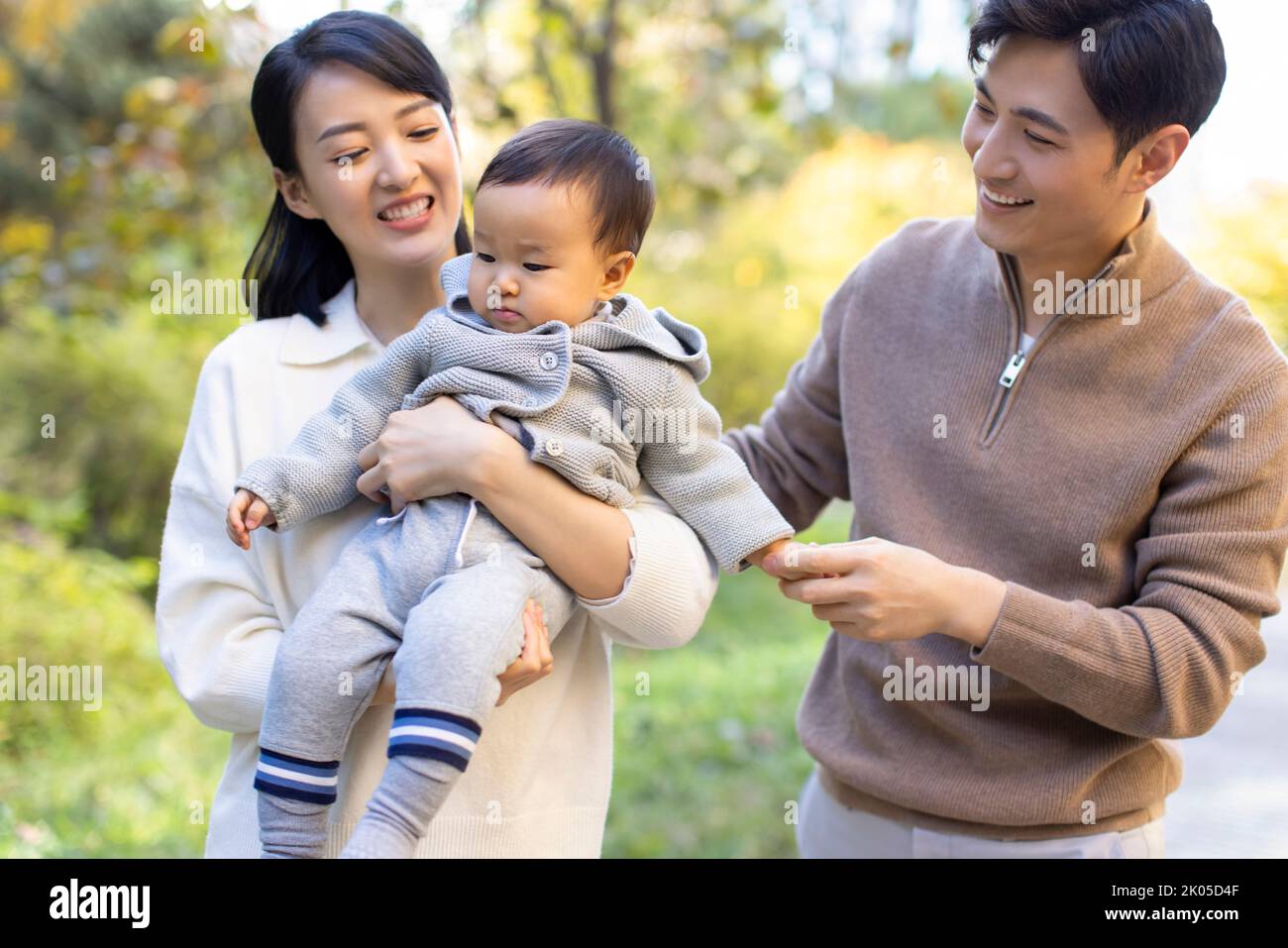 Young Chinese parents playing with baby in park Stock Photo - Alamy