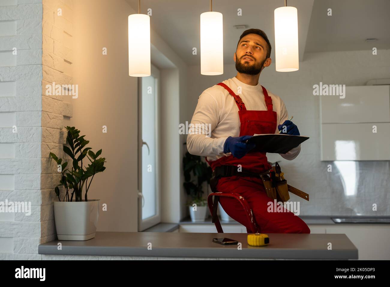 Installation lighting. Builder is holding a tablet in his hands ...