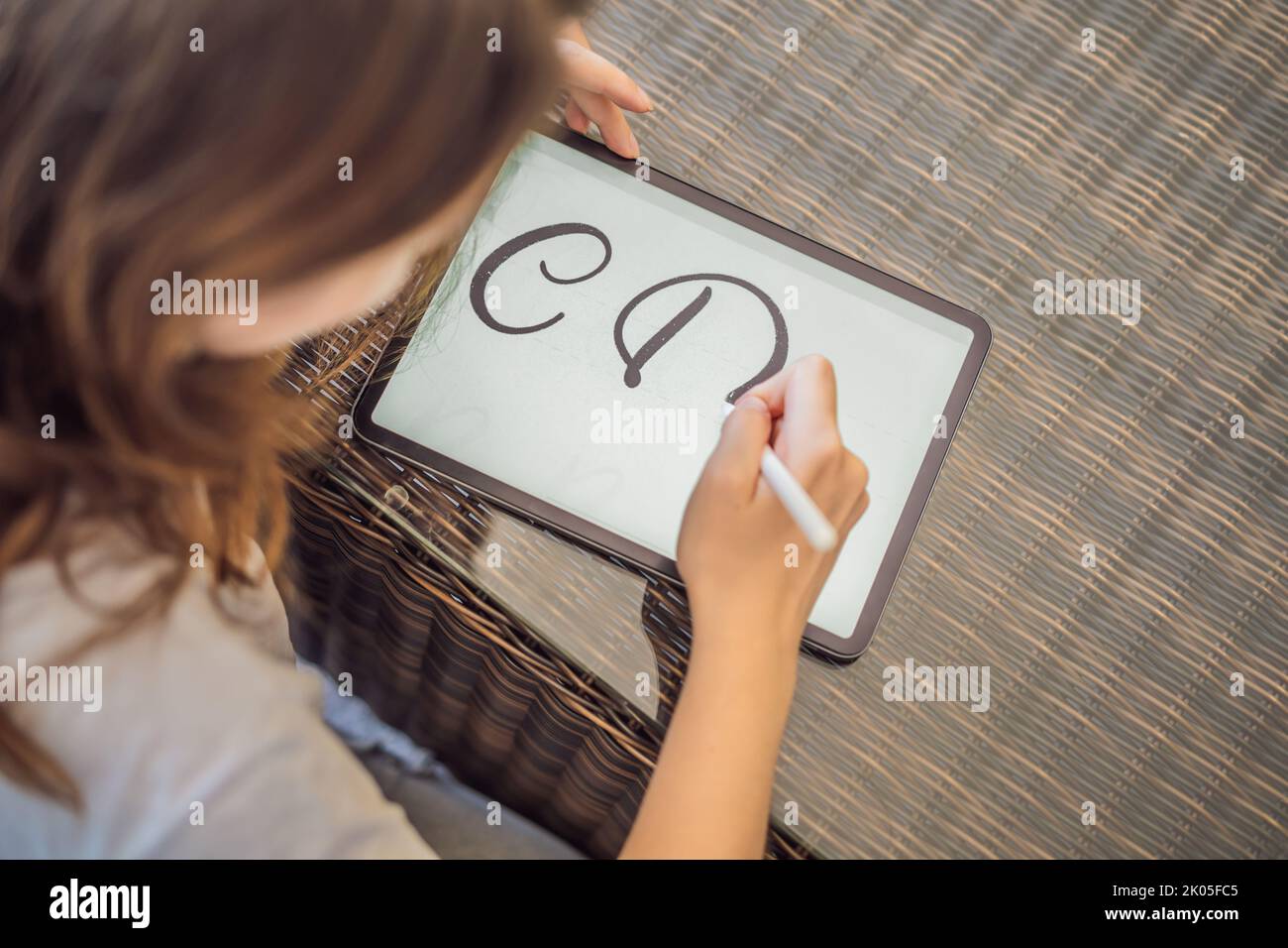 Calligrapher Young Woman writes phrase on digital tablet. Inscribing ...