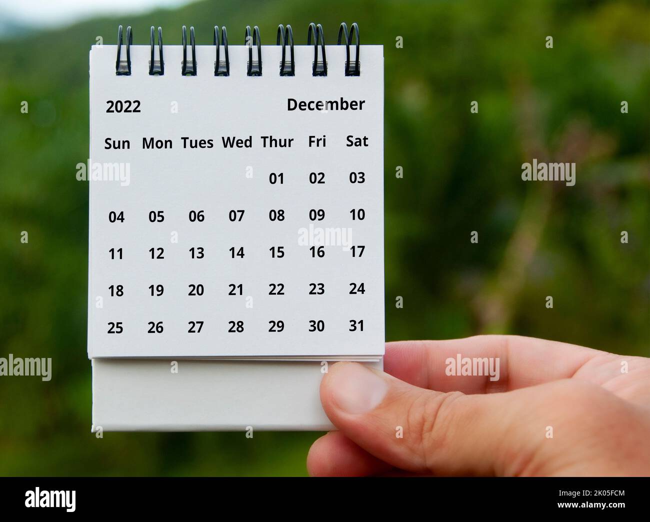Hand holding December 2022 calendar with copy space and nature ...