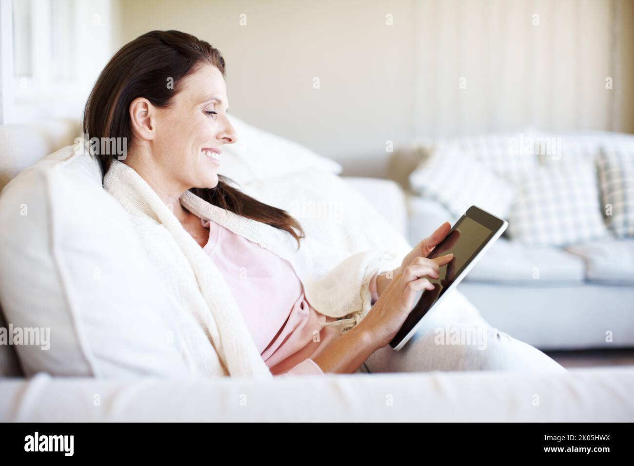 Woman lounging on sofa using hi-res stock photography and images - Alamy