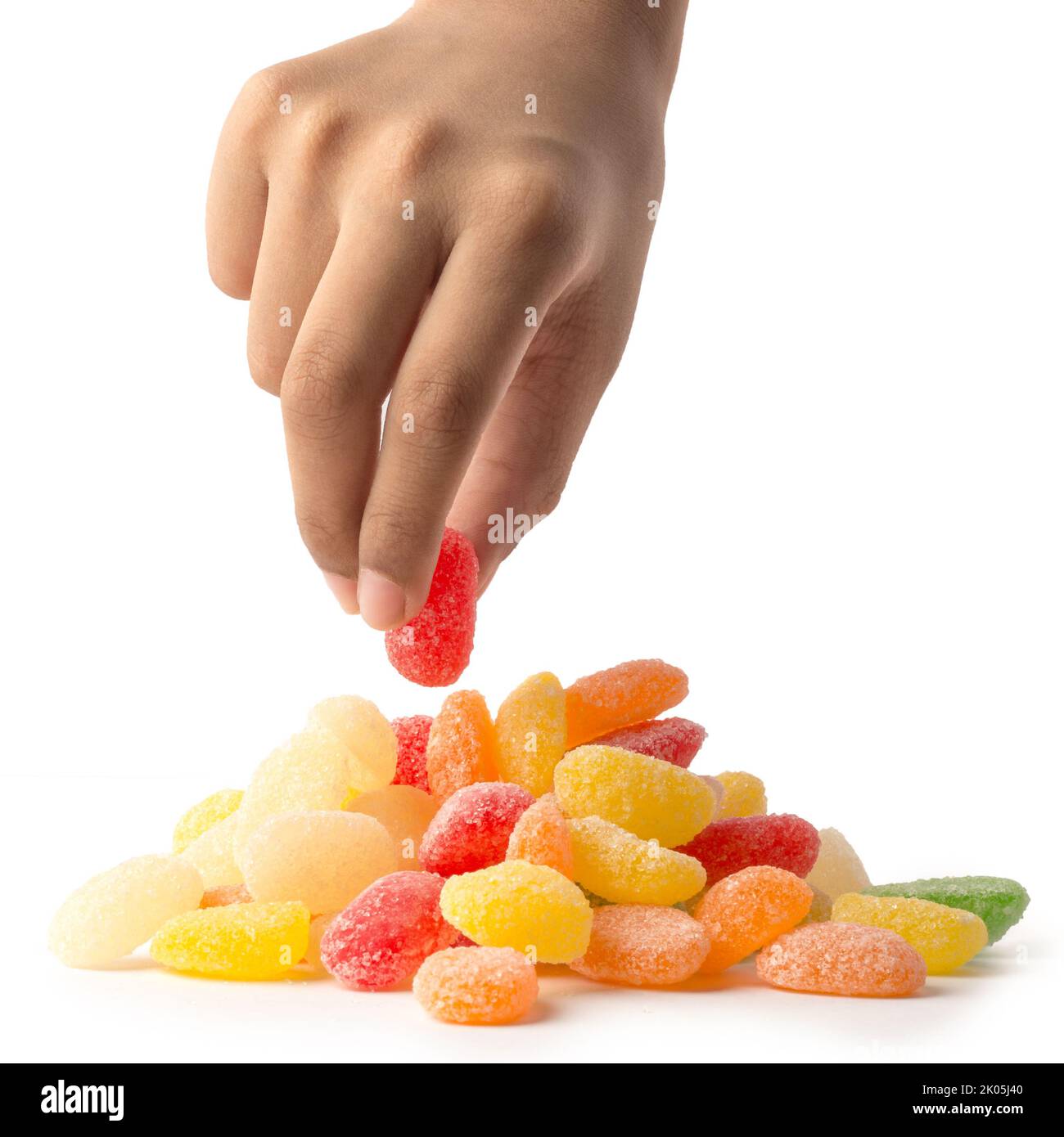 hand picking up jujube, from a pile of colorful gummy type of candy ...