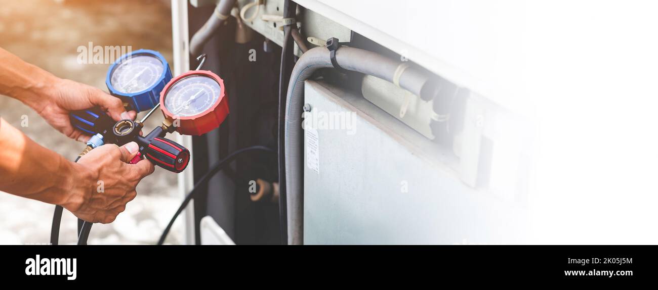 Air repair mechanic using measuring equipment for filling industrial ...