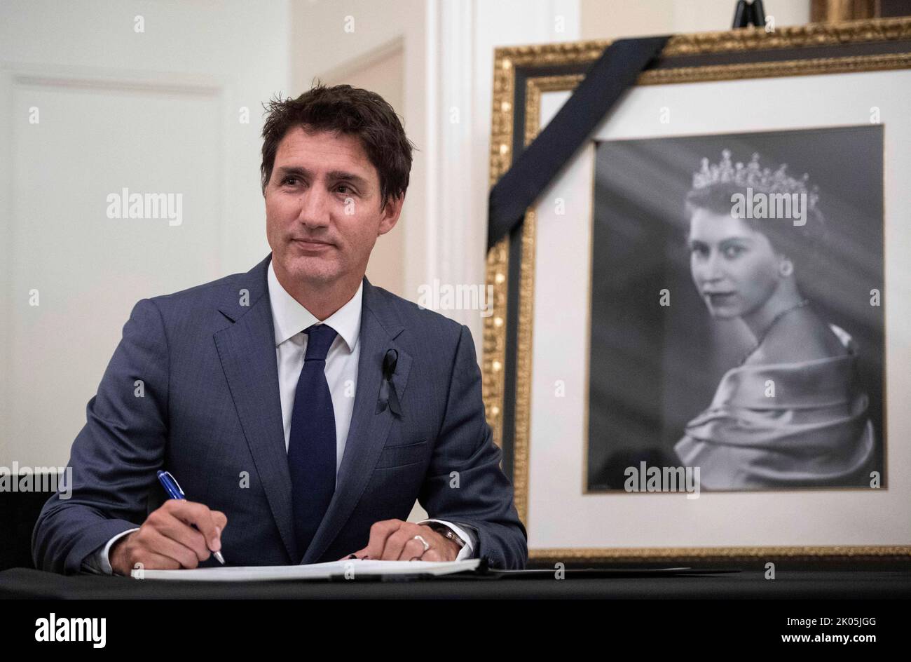 Prime Minister Justin Trudeau looks up after signing a book of ...