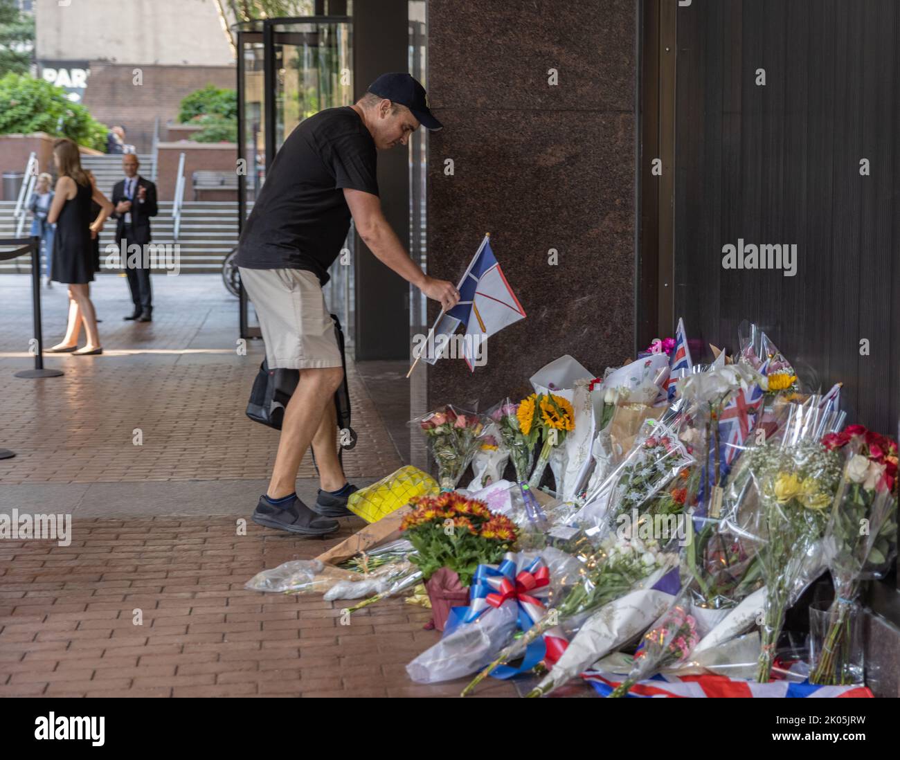 NEW YORK, N.Y. – September 9, 2022: A person leaves a flag at a tribute ...